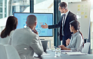 four people in a meeting presenting graphs