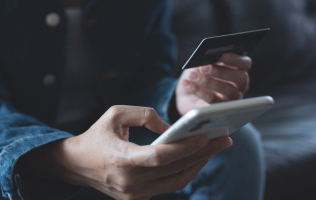 person holding phone and credit card